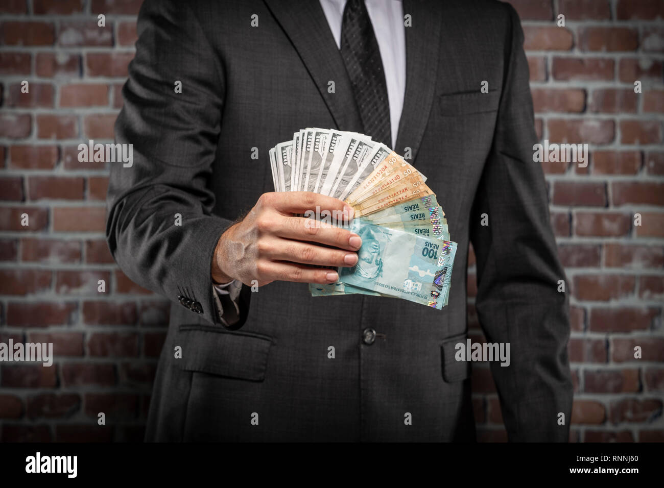 Brazilian man holding bills of money with a handcuff in a jail. concept ...
