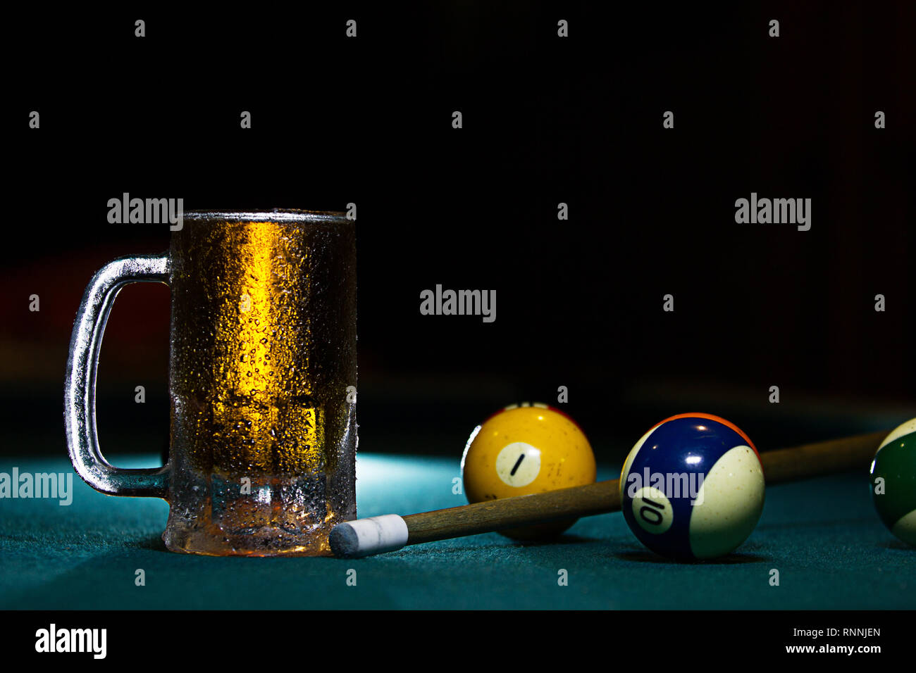isolated cold frozen beer mug with billiard balls and cue on black ...
