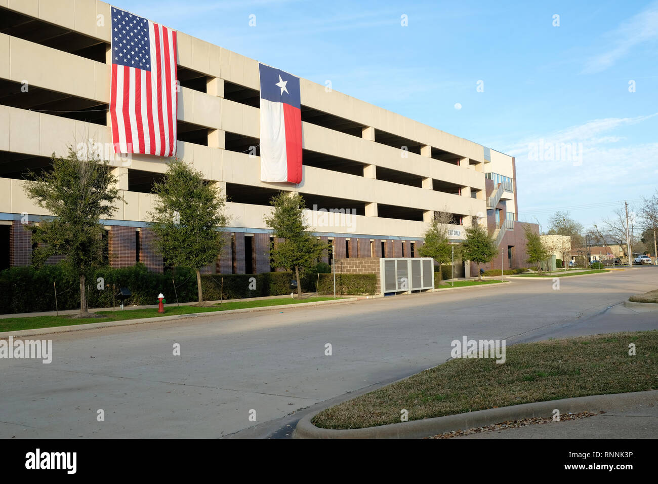 American and Texas flags draped over the side of the Roy Kelly Parking ...