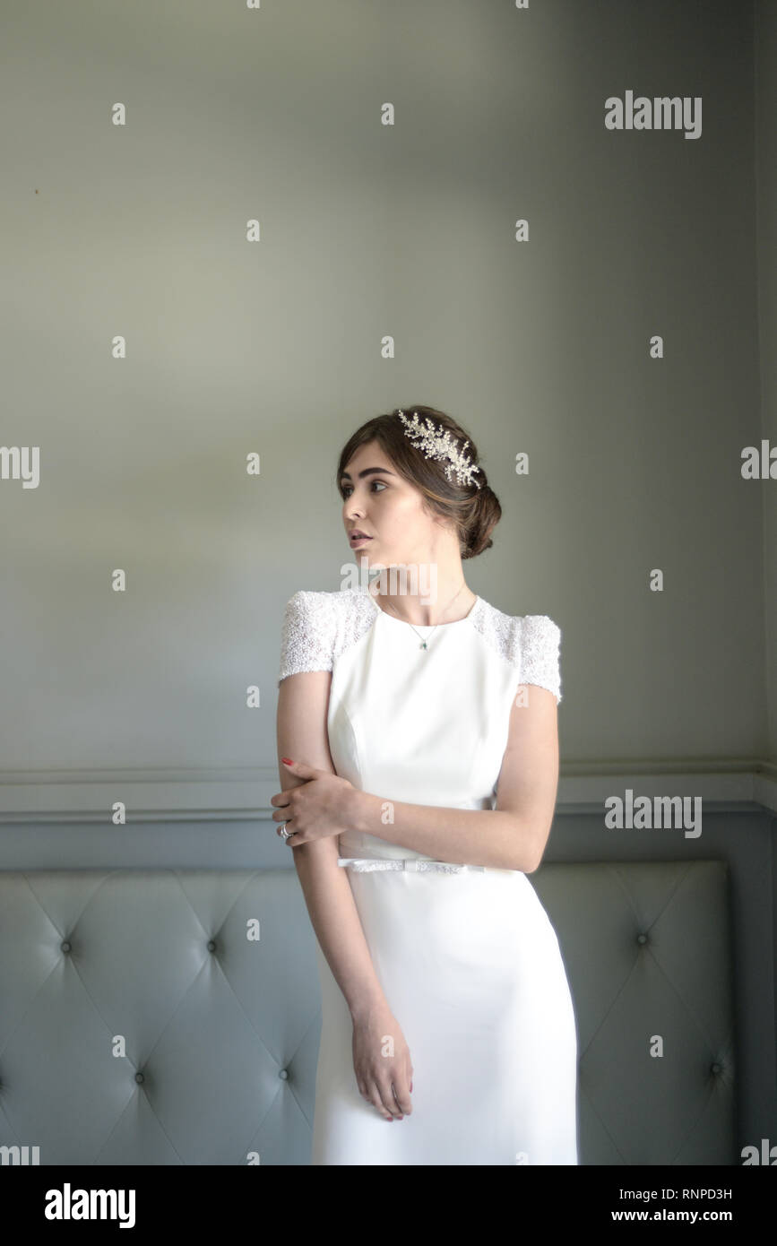 A young pensive couple have a traditional English White Wedding, they are both dark haired and ...