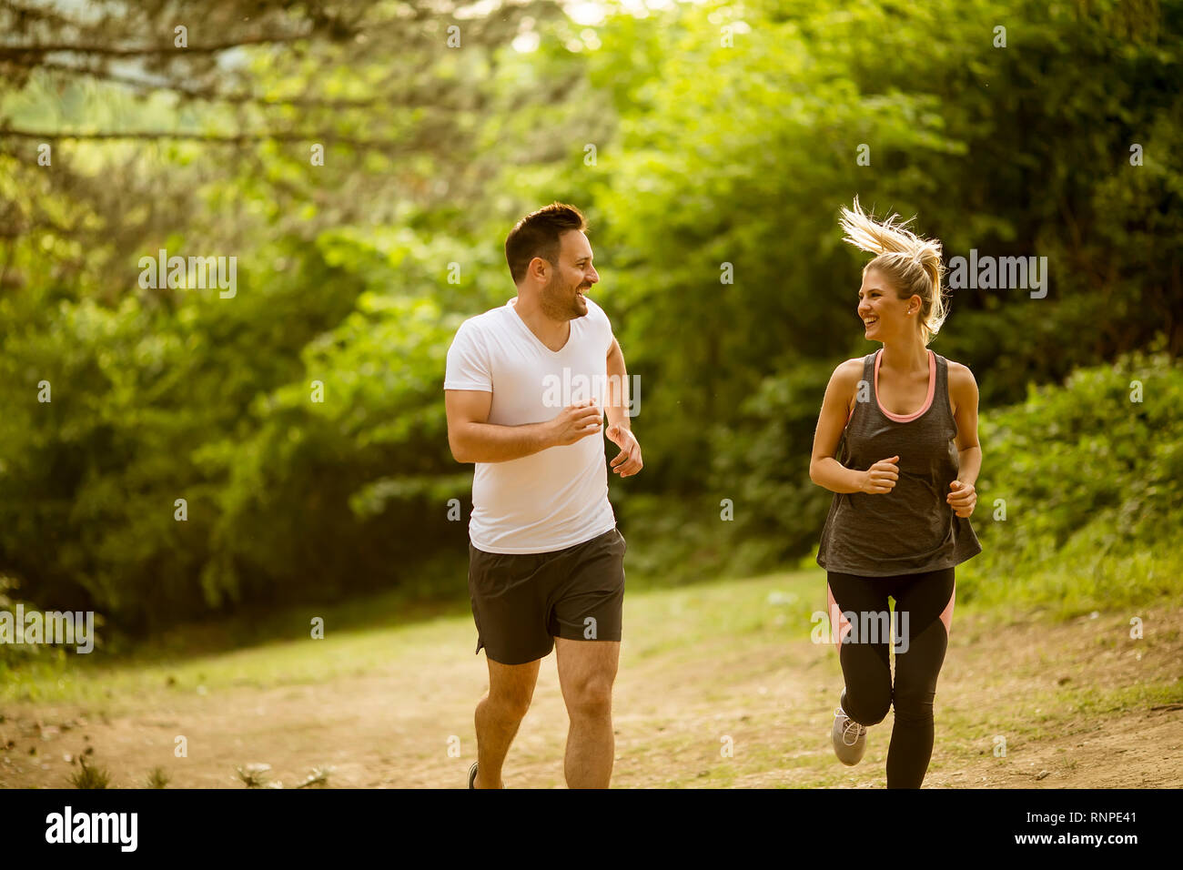 Healthy fit and sportive couple running in nature at summer day Stock ...