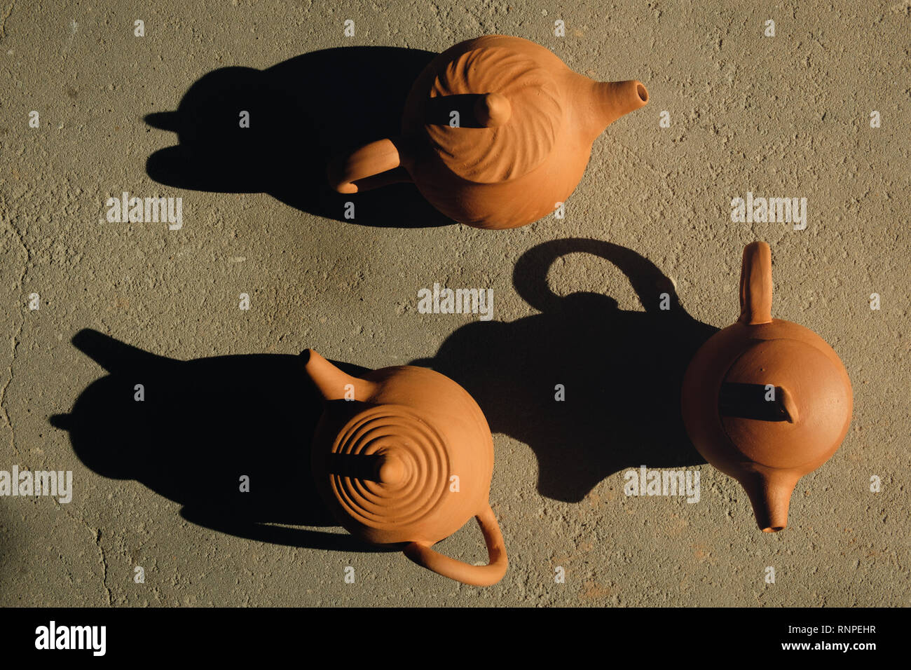 Flat lay three ceramic pottery tea pots made from clay drying in the ...