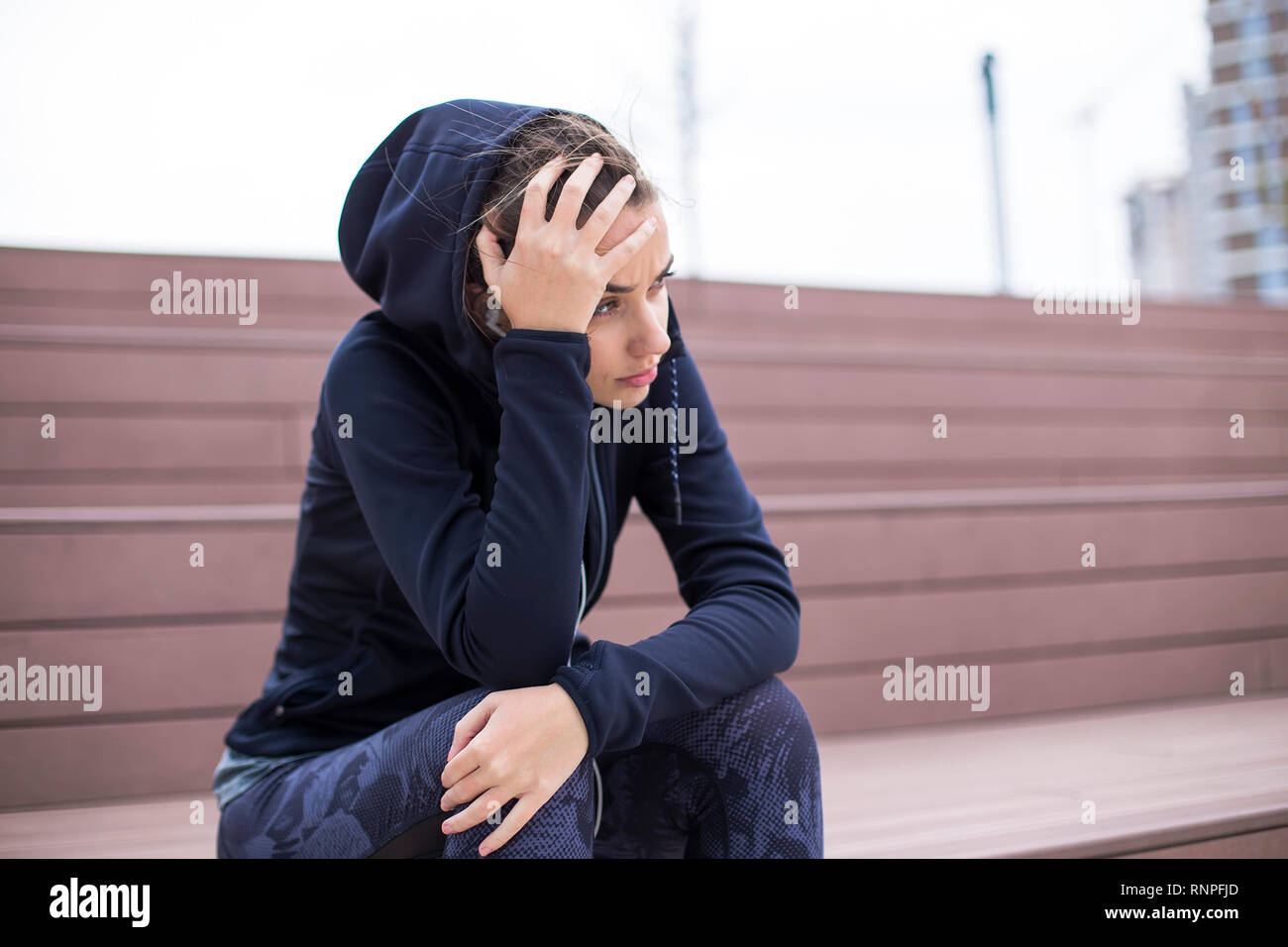 Portrait of worried, sad and depressing young woman sits outside Stock ...