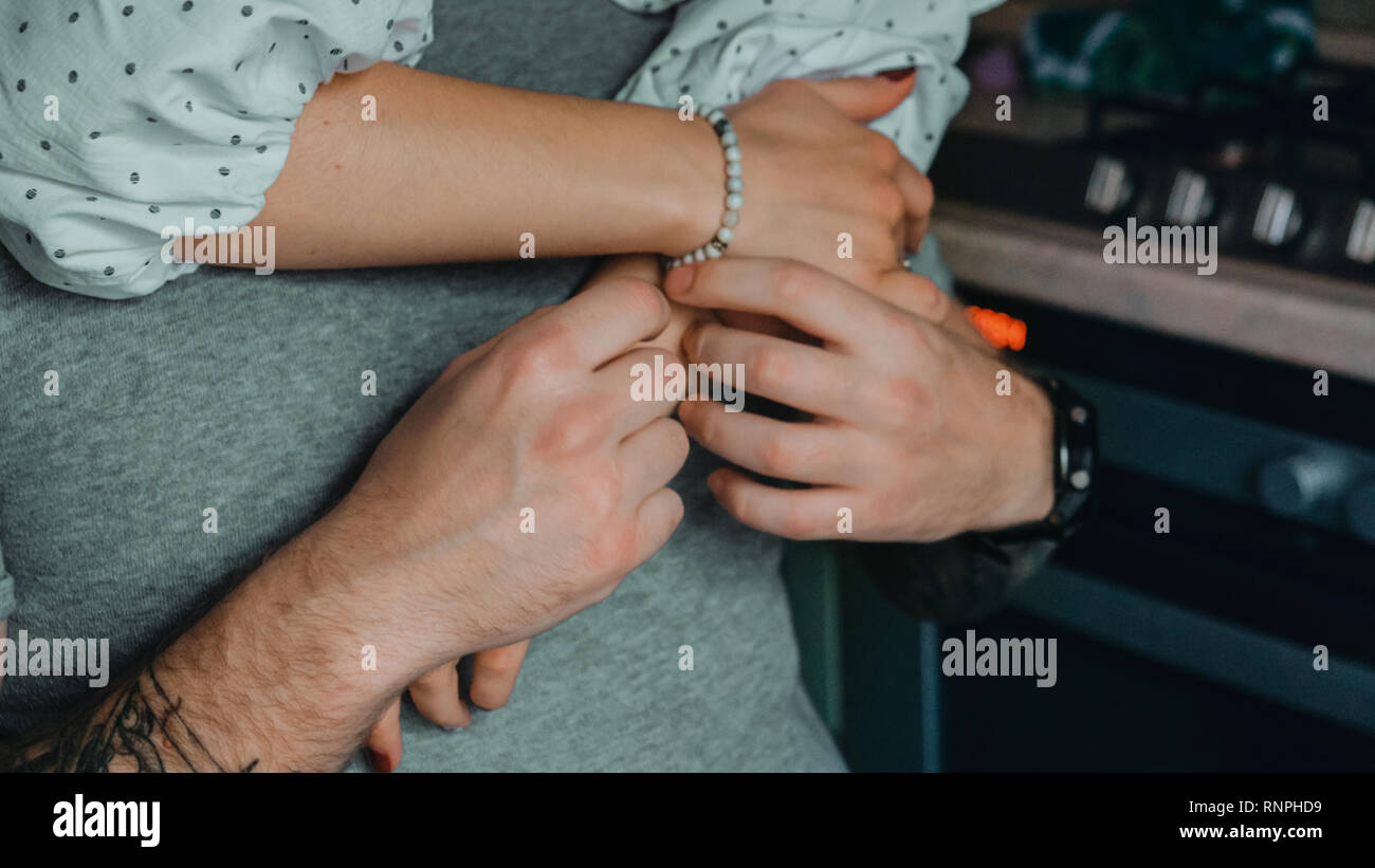 Close-up man and woman holding their hands in the kitchen. Hands ...