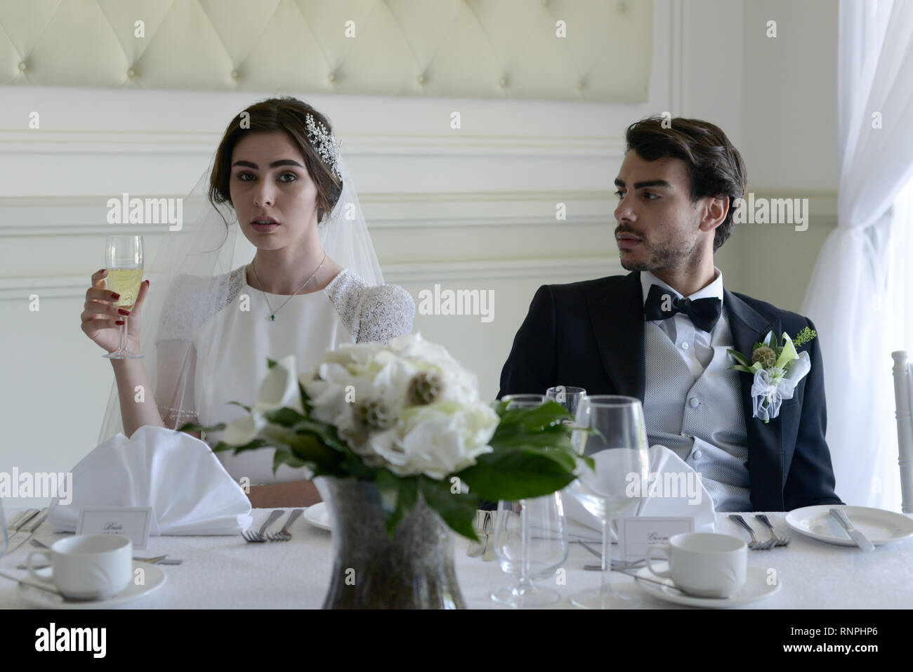 A young pensive couple have a traditional English White Wedding, they ...