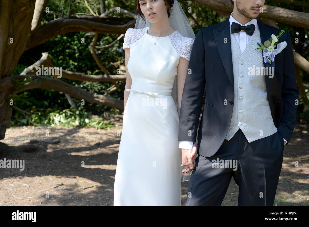 A young pensive couple have a traditional English White Wedding, they ...