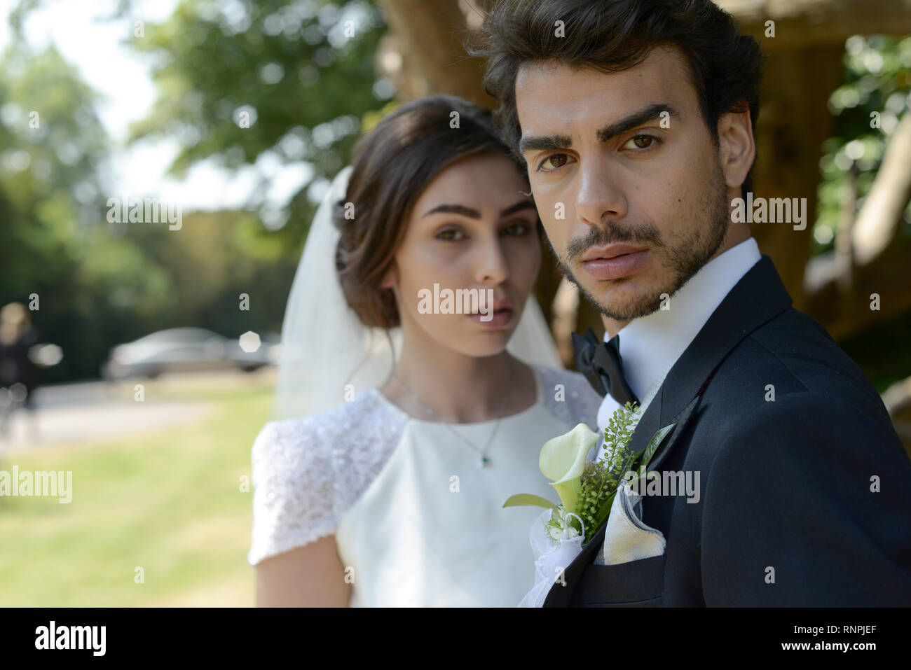 A young pensive couple have a traditional English White Wedding, they ...