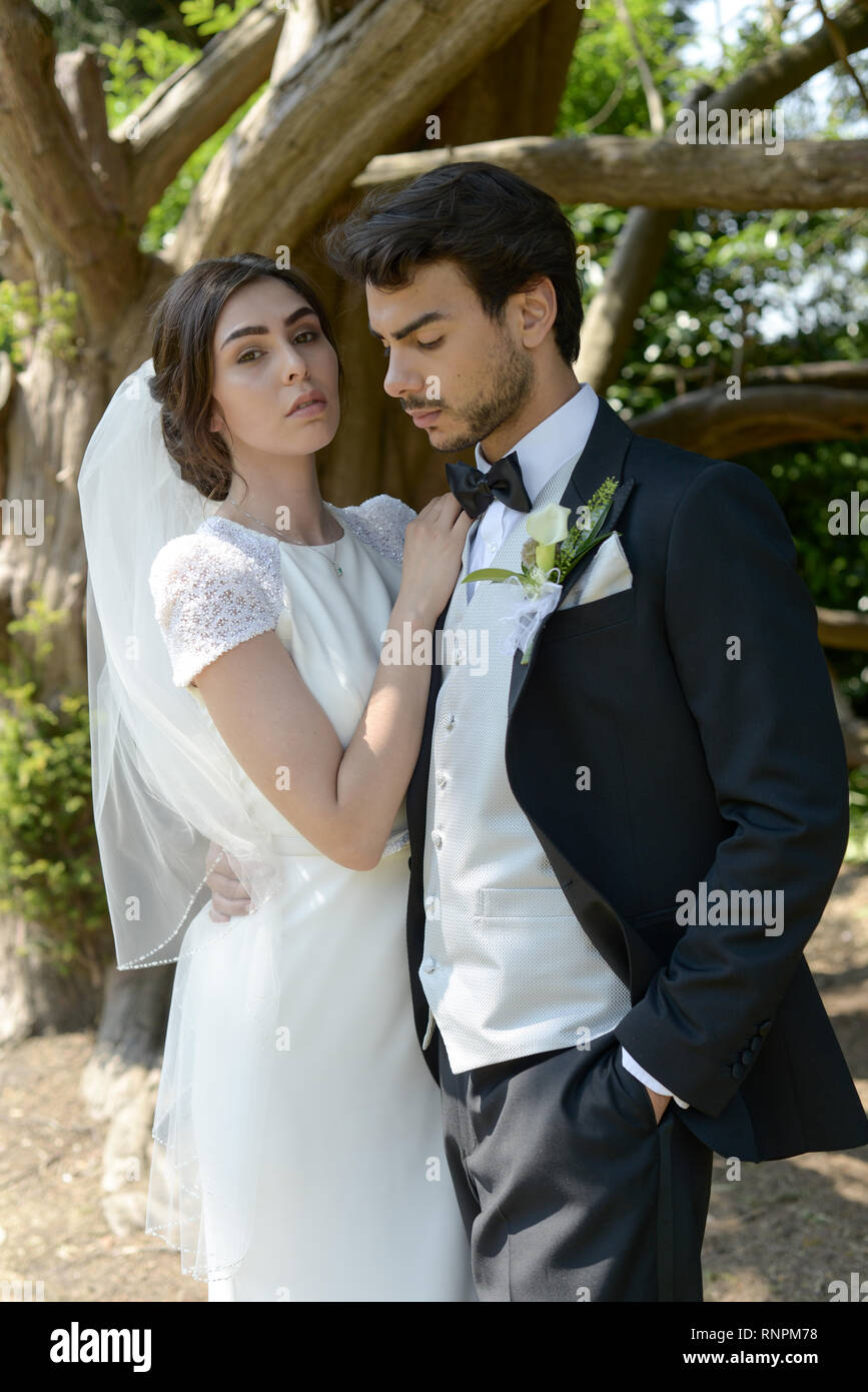 A young pensive couple have a traditional English White Wedding, they ...