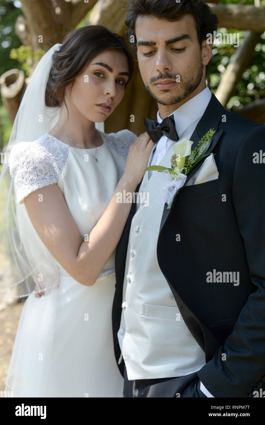 A young pensive couple have a traditional English White Wedding, they ...