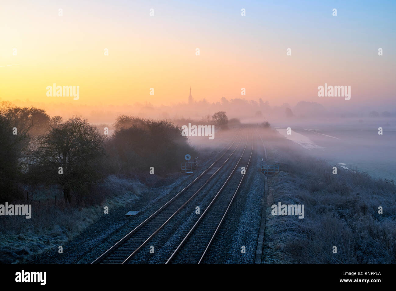 Train tracks in the mist at sunrise in the winter frost. Kings Sutton ...