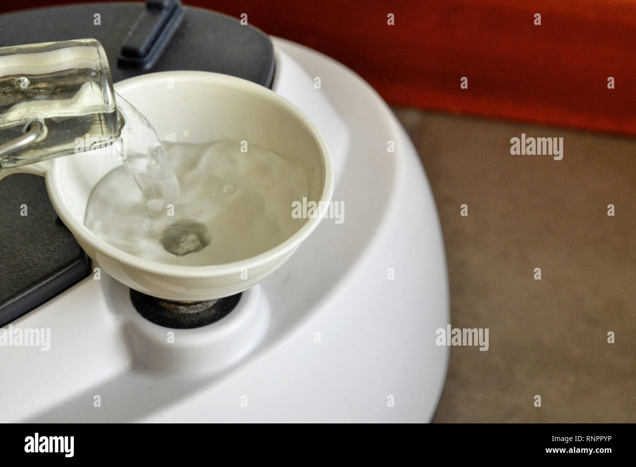 The steam iron boiler is supplied with water: the transparent glass ...