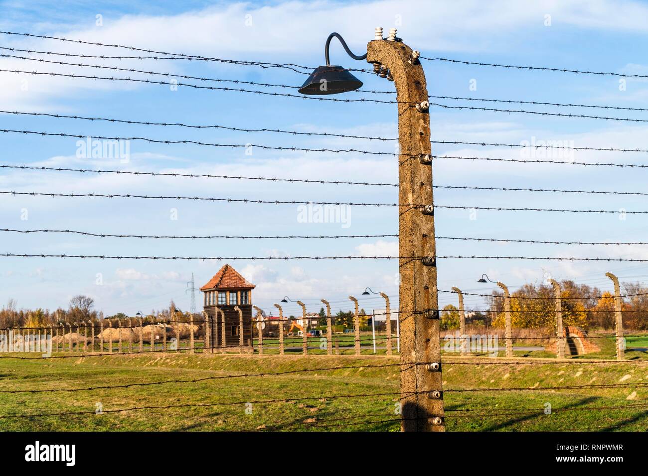 Barbed wire fence with watchtower surrounding Auschwitz concentration ...