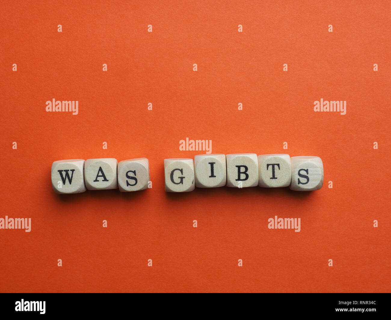 Small wooden blocks with the German words What's up on an orange ...