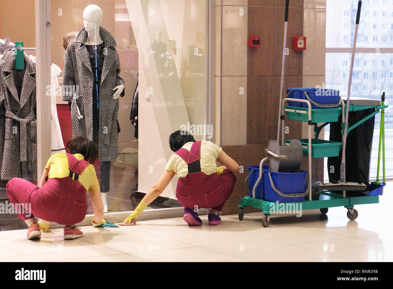 Image of the cleaners at the Mall. Two women wipe stains on the floor ...
