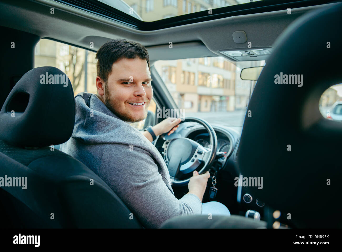 young adult smiling man driving car. road trip Stock Photo - Alamy