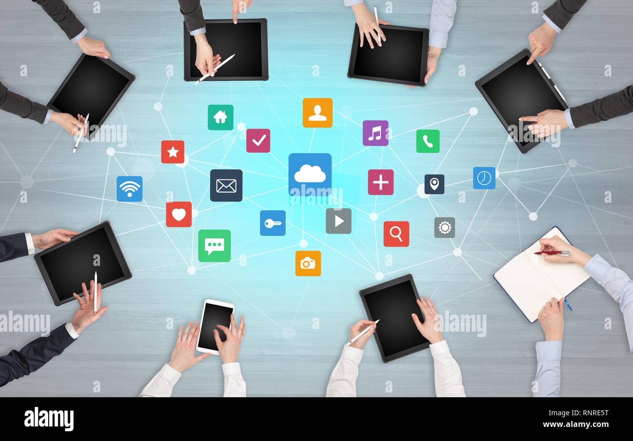Group of people with devices in hands working in team on tablets ...