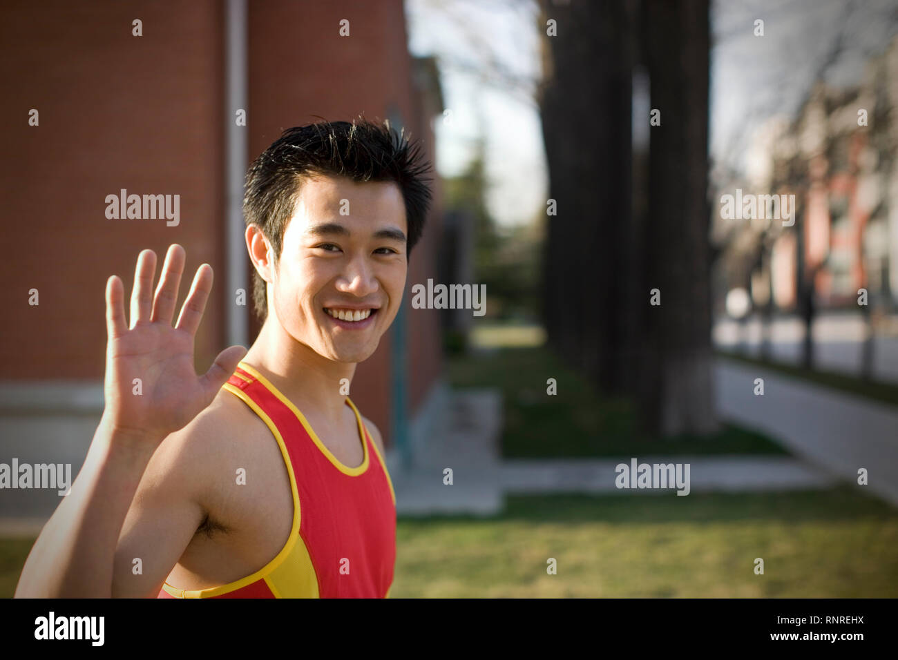 Portrait of a young adult man waving Stock Photo - Alamy