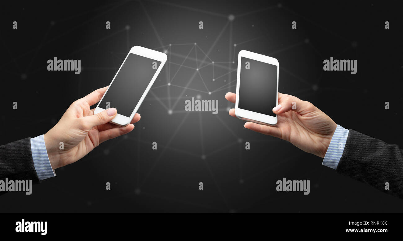 Close up of two hands holding smartphones to each other, wireless ...