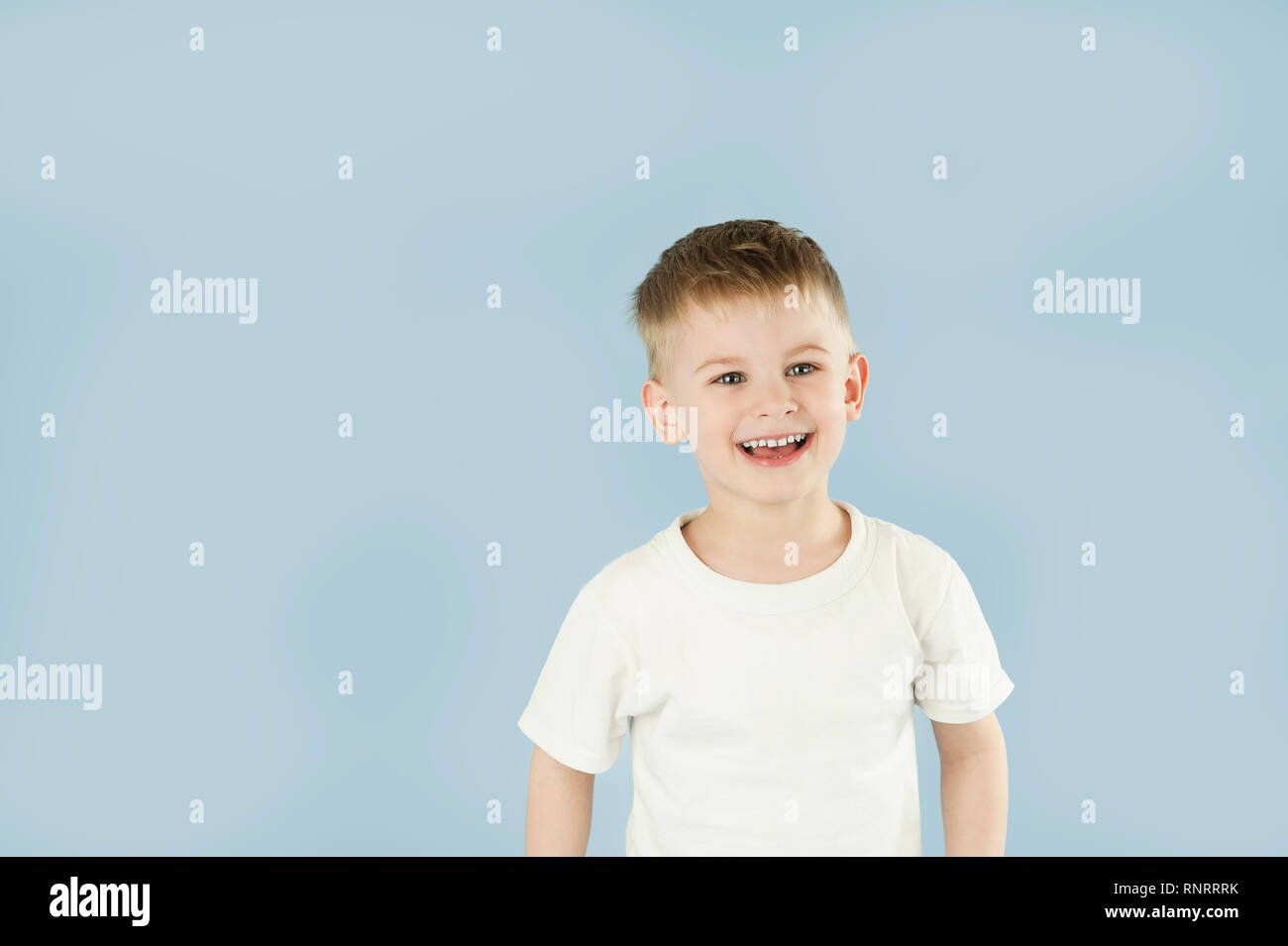 Portrait of an emotional handsome boy on an isolated blue background ...