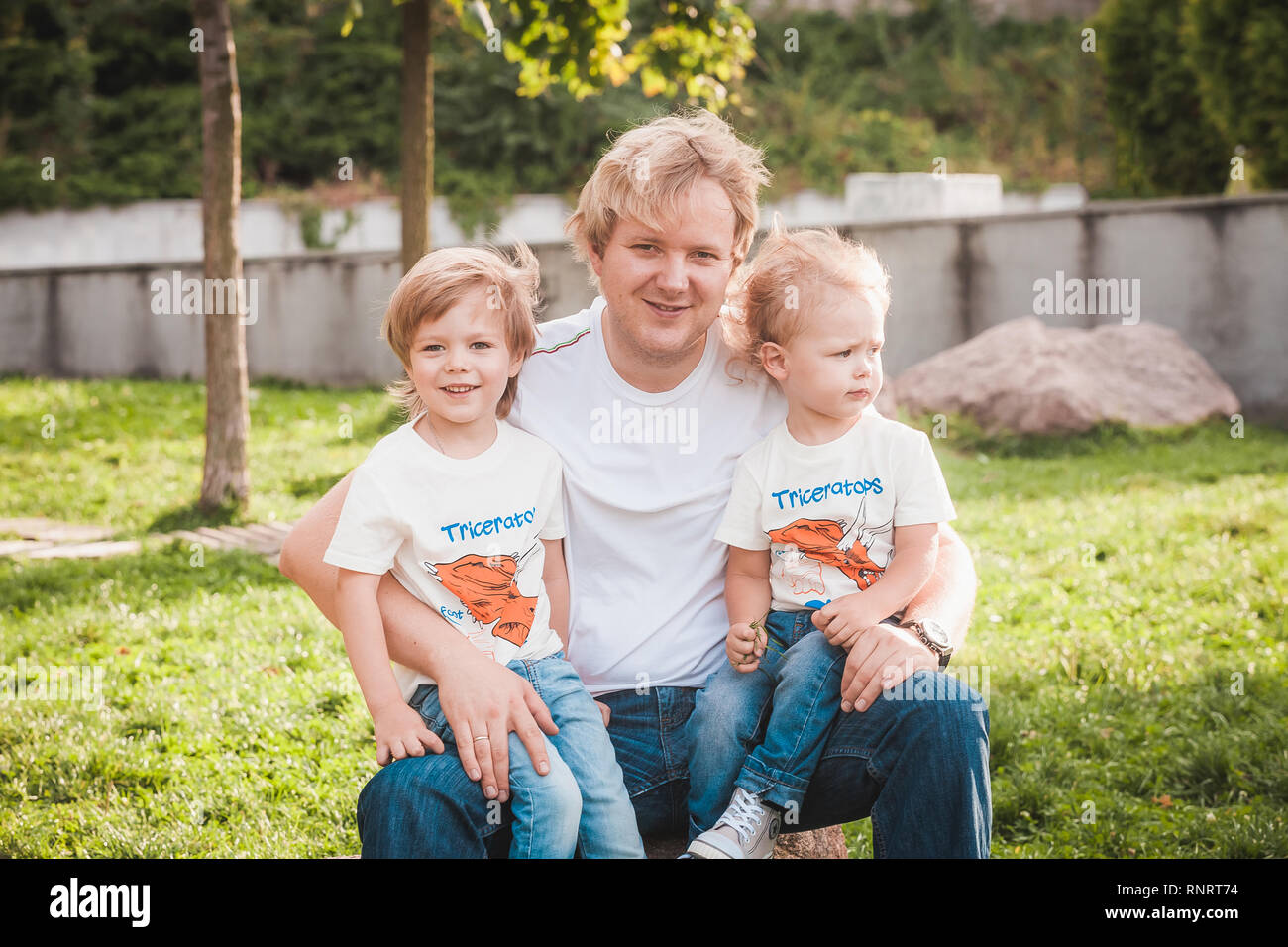 Happy father with two little sons in park Stock Photo - Alamy