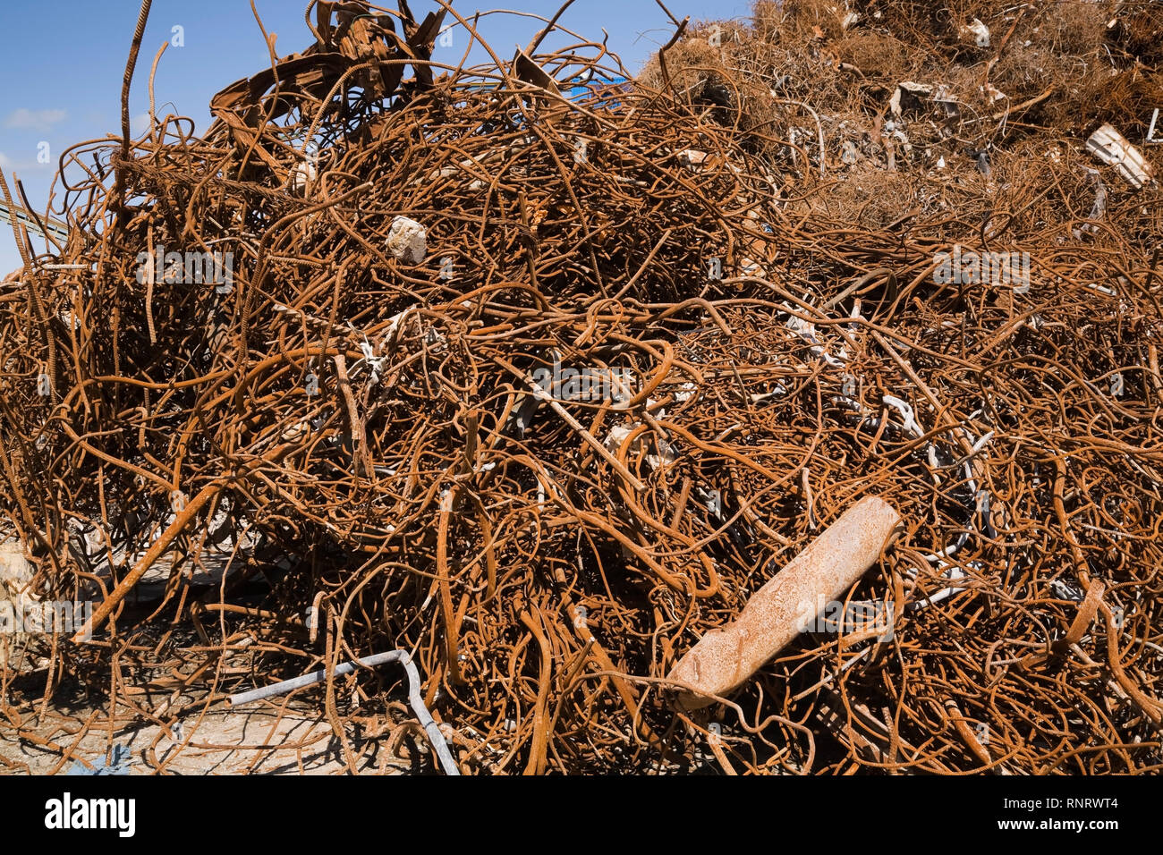 Pile of assorted rusted metal rods and pipes in scrap metal recycling ...