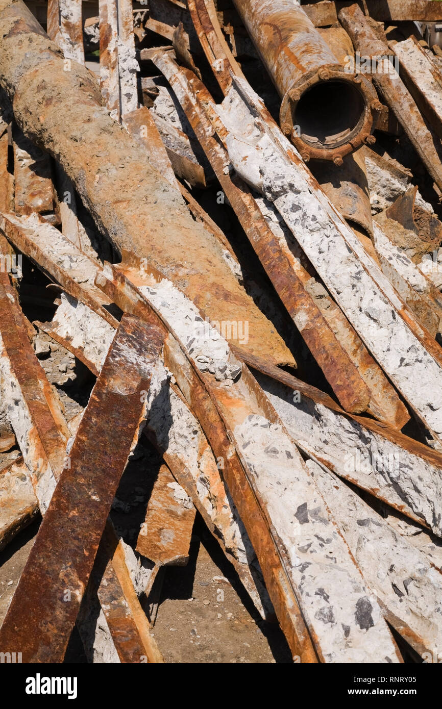 Pile of rusted ferrous metal pipes and beams at a scrap metal recycling ...