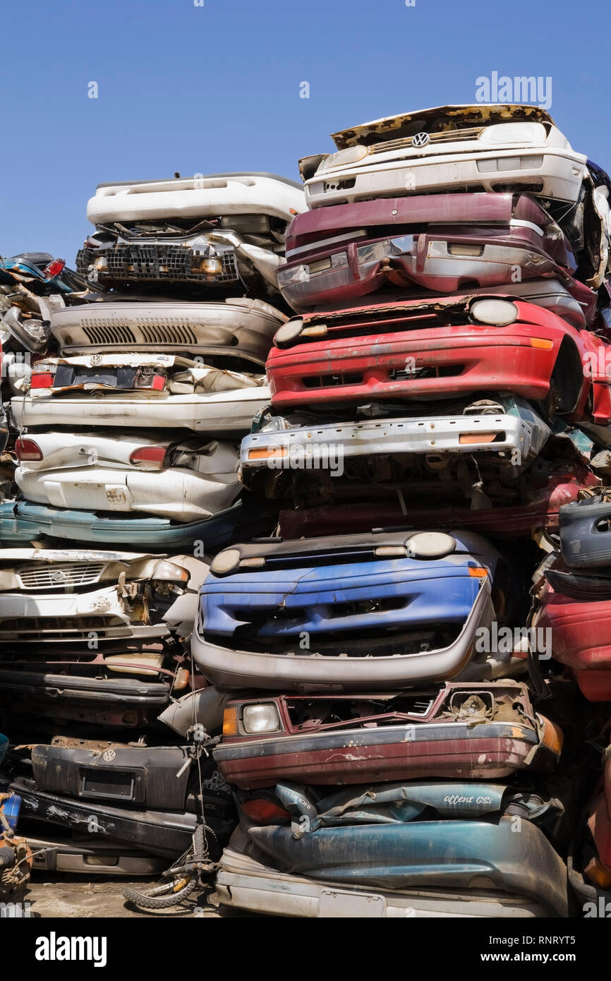 Stacked and crushed automobiles at a scrap metal recycling junkyard ...