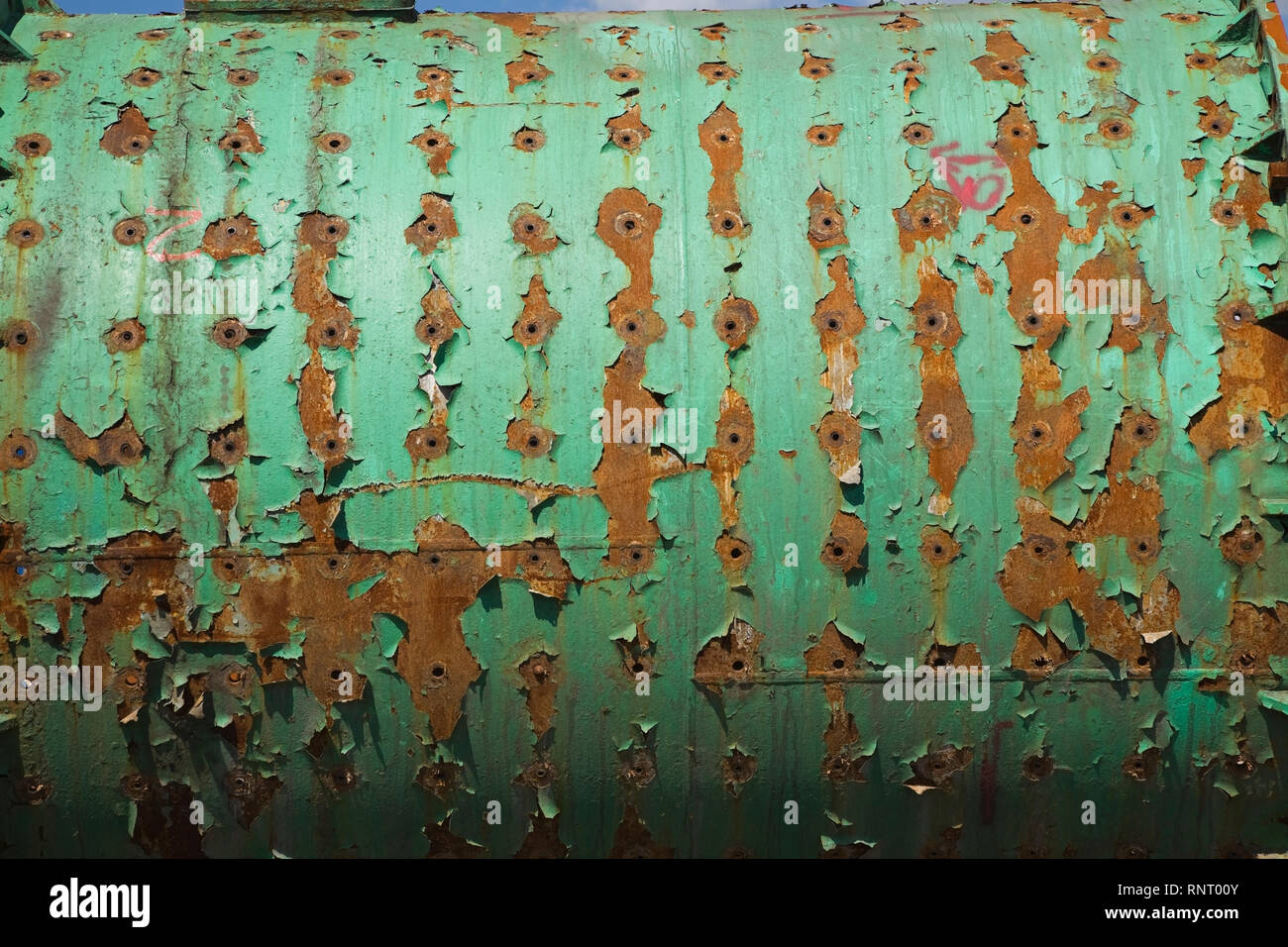 Close-up of an industrial size rusted ferrous metal cylindrical chamber ...