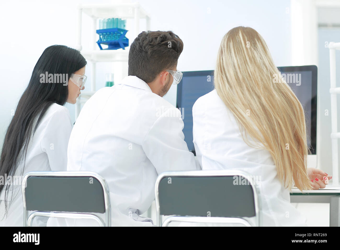 rear view.a group of scientists use computers to analyze information ...