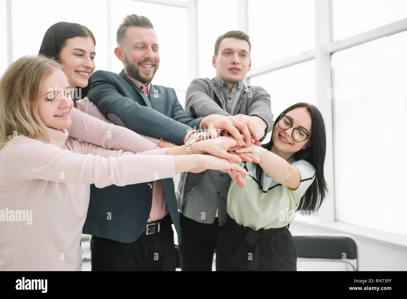 International business team showing unity with their hands together ...