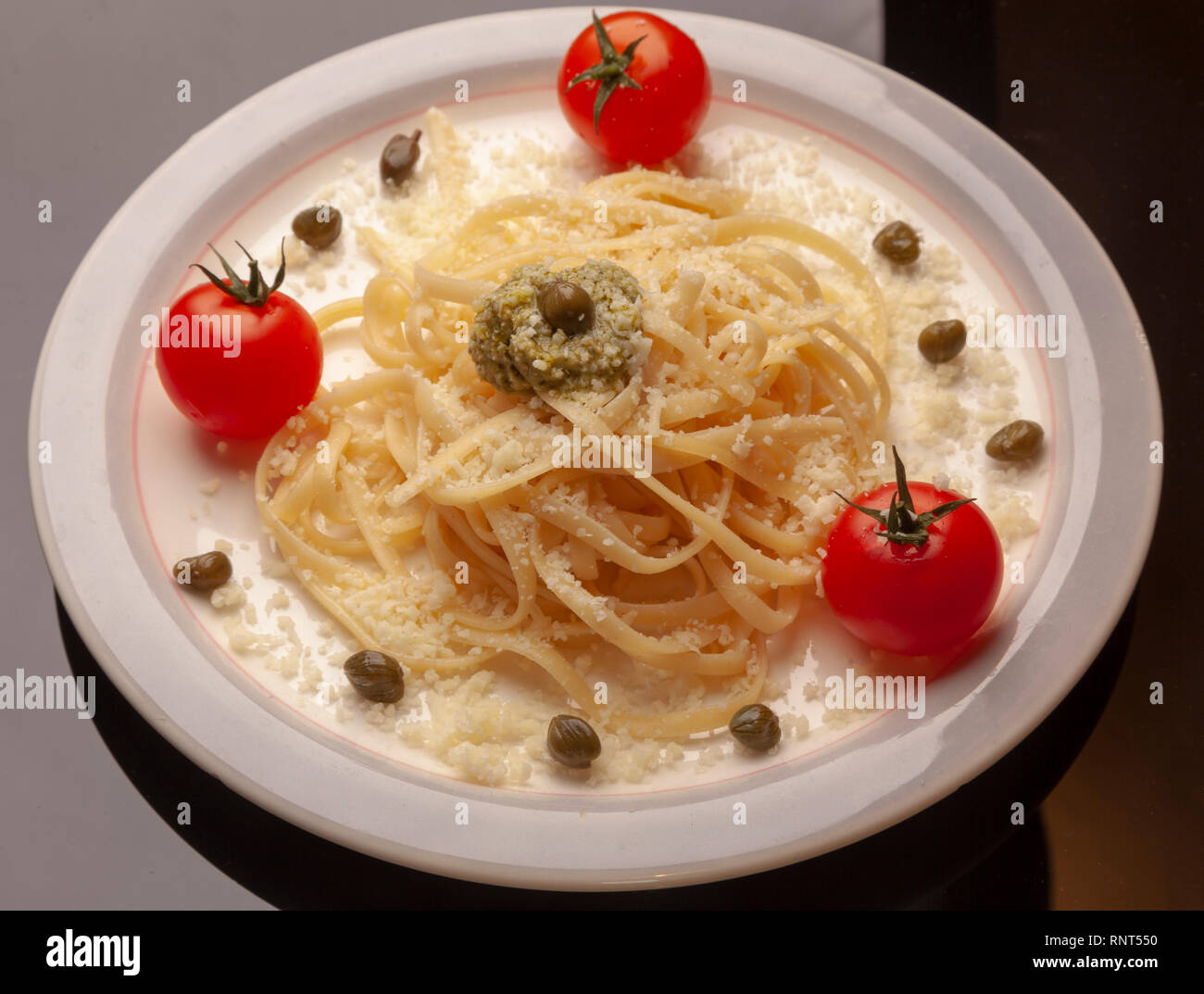 Linguini spaghetti with pesto and small tomatoes Stock Photo - Alamy