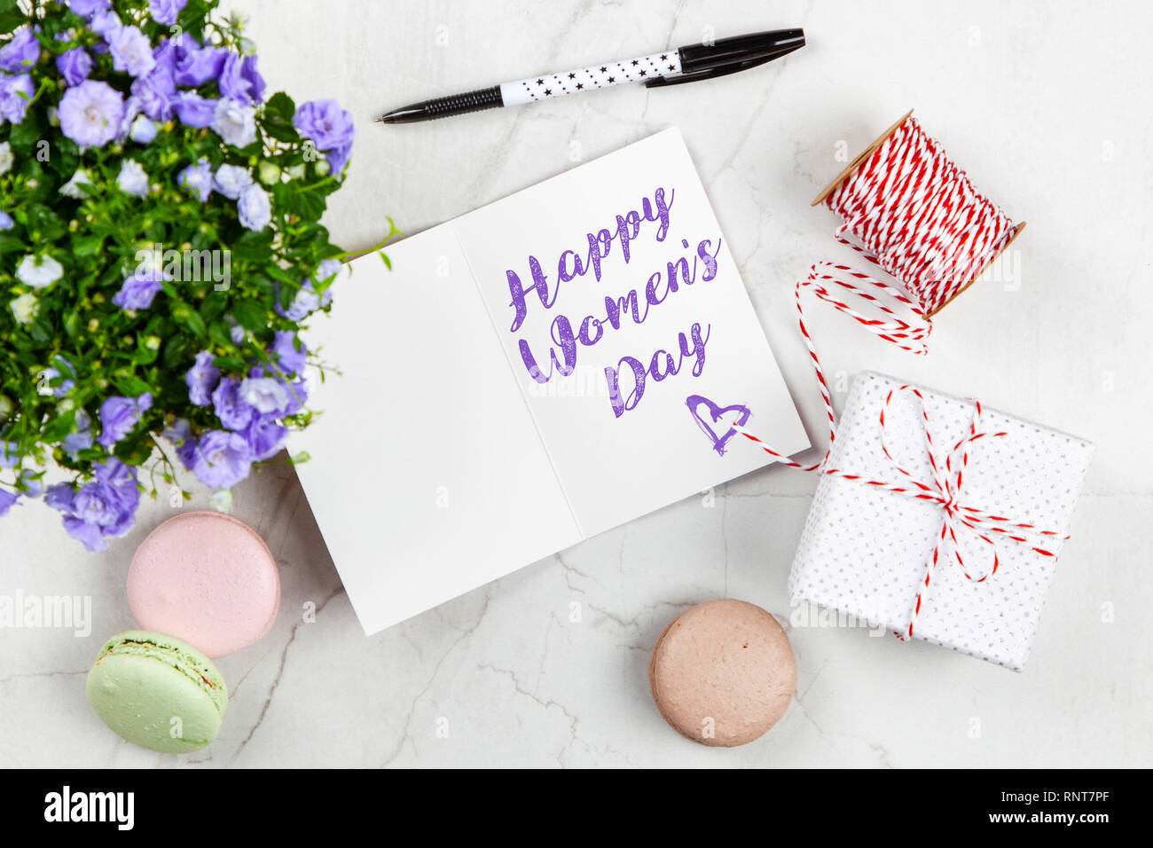 Happy Women's Day postcard note on white marble table Stock Photo - Alamy