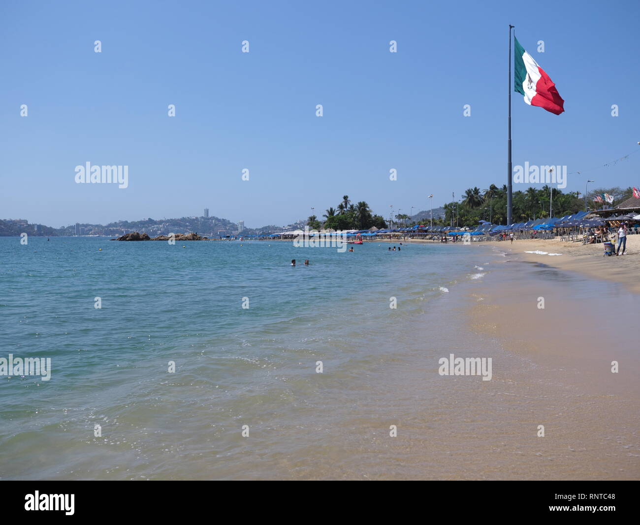 Scenery of sandy beach with mexican flag at bay of ACAPULCO city in ...