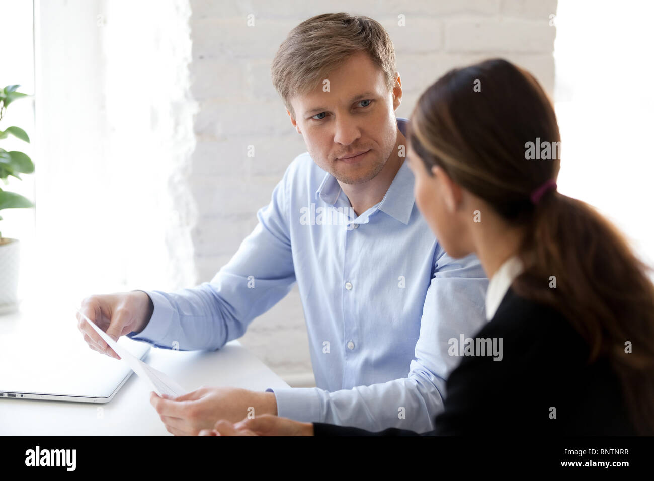 Hr manager and applicant sitting at desk during job interview Stock ...