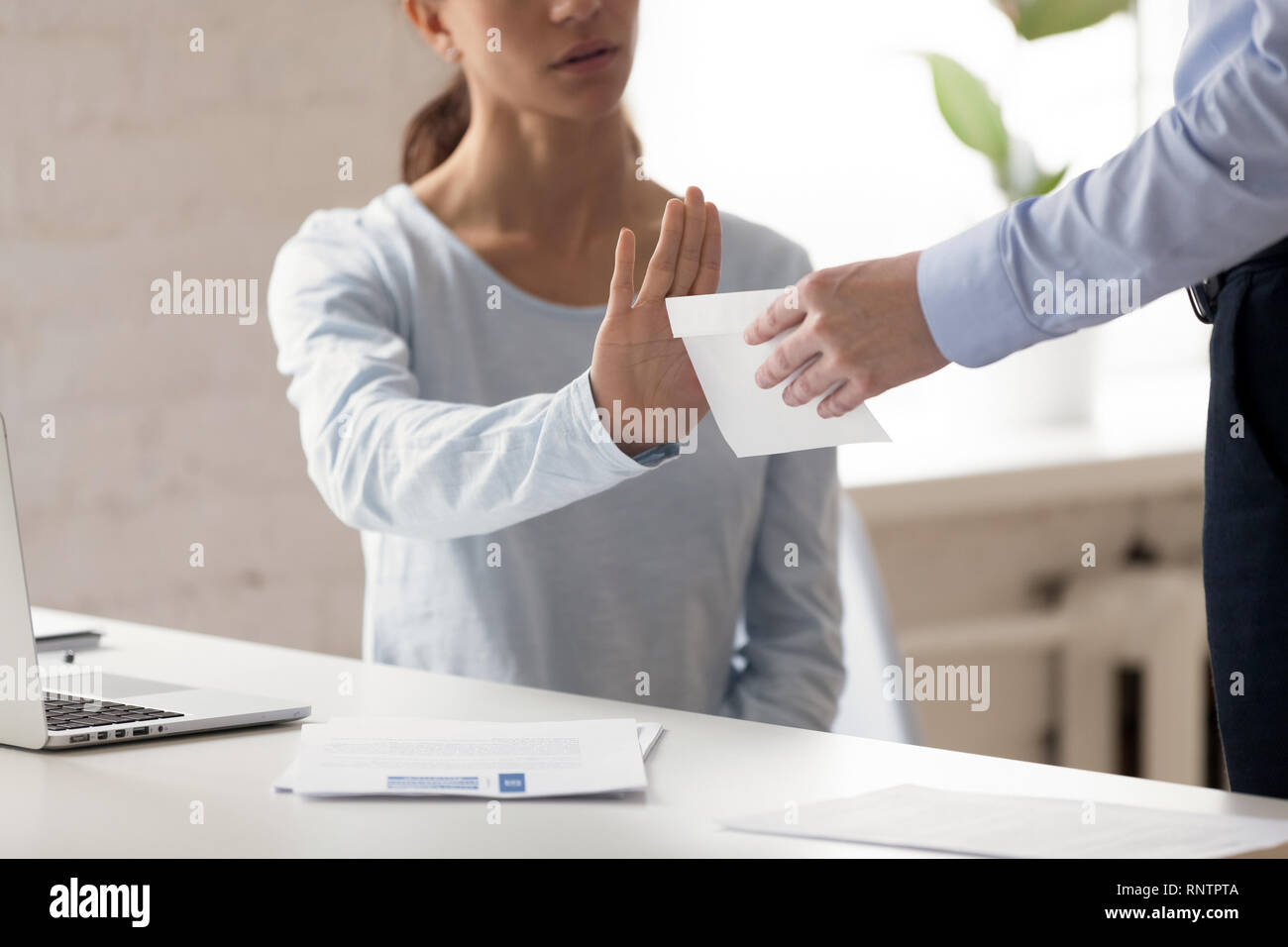 Woman refusing money in the envelope offered by man Stock Photo - Alamy