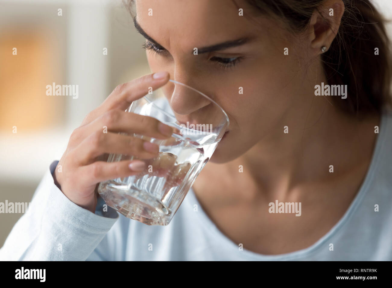 Close up female face holding glass of water Stock Photo - Alamy