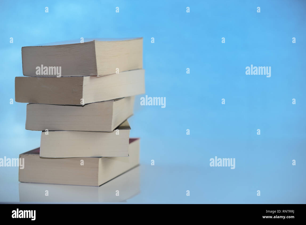 Pile of old paper books against blue background Stock Photo - Alamy