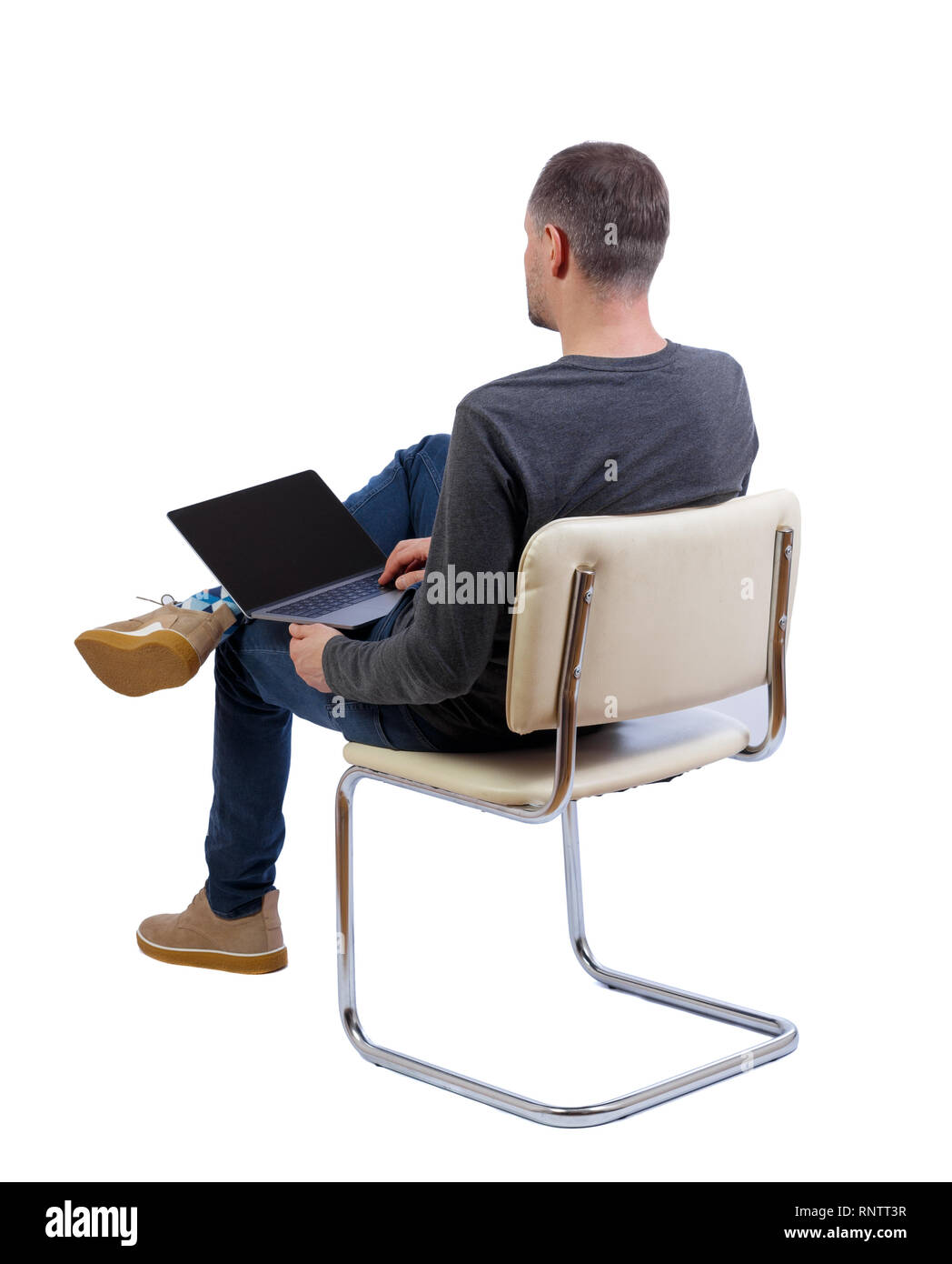 Back view of a man who sits on a chair with a laptop. Rear view people ...