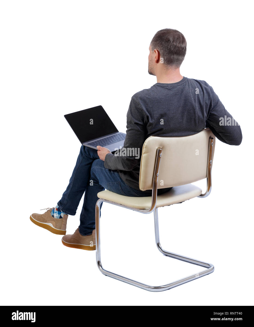 Back view of a man who sits on a chair with a laptop. Rear view people ...
