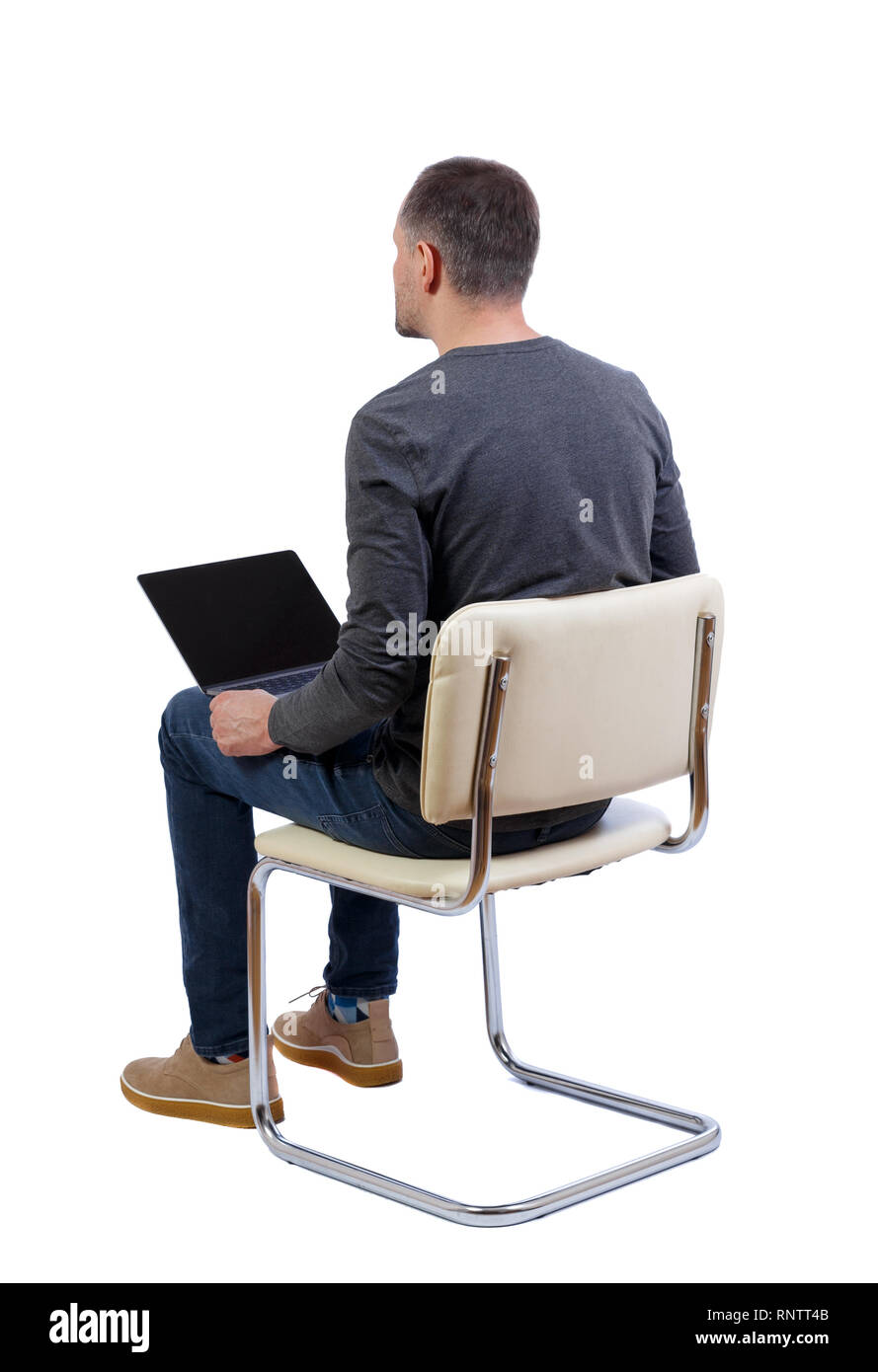 Back view of a man who sits on a chair with a laptop. Rear view people ...