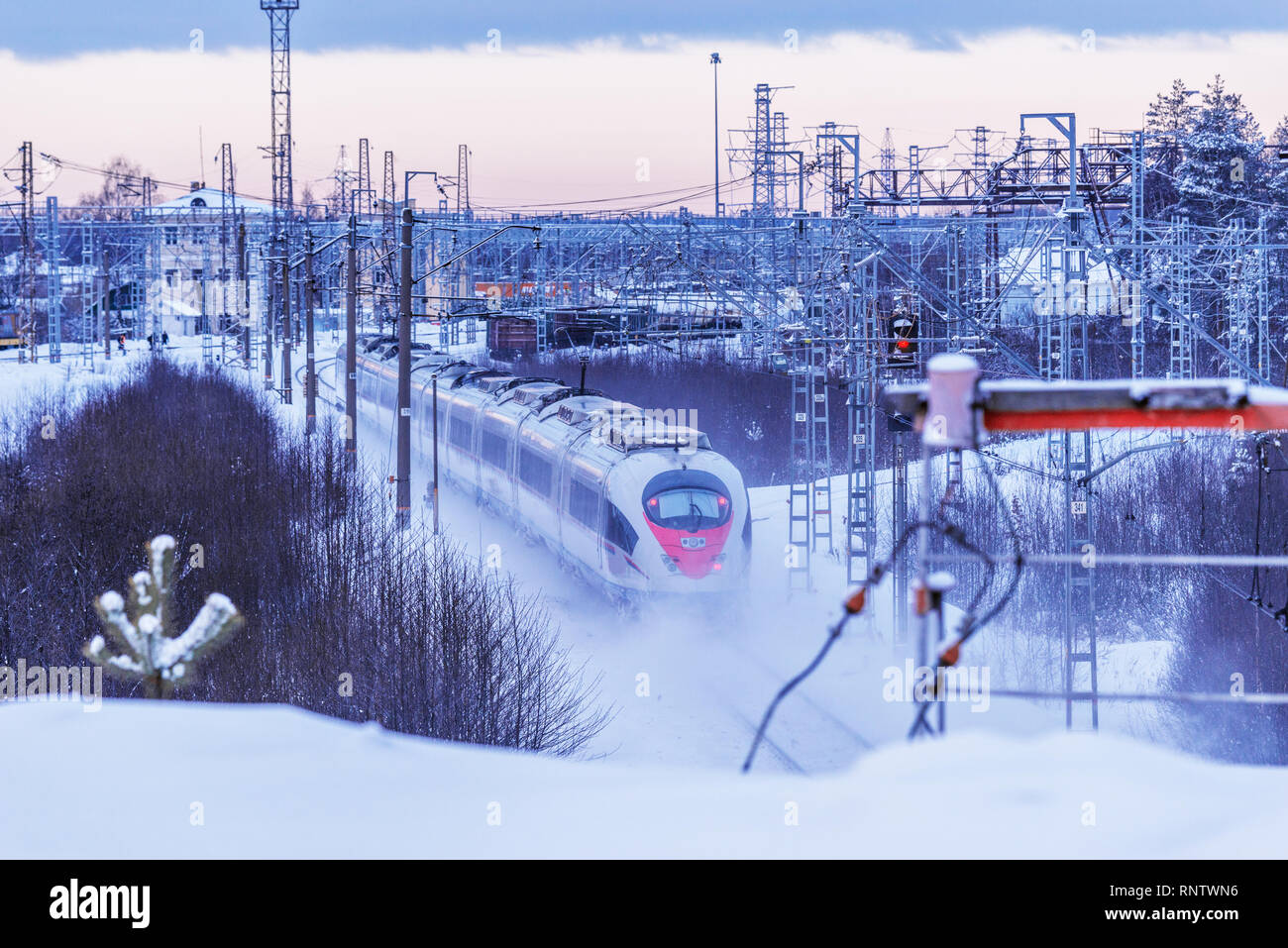 Modern high-speed train moves through the station at winter morning ...