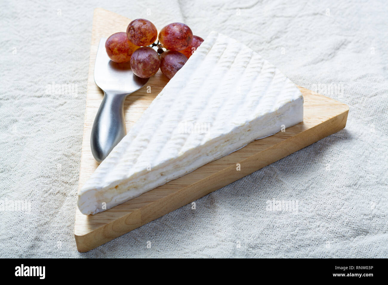 One piece of French soft cheese Brie with white mold and strong odor ...