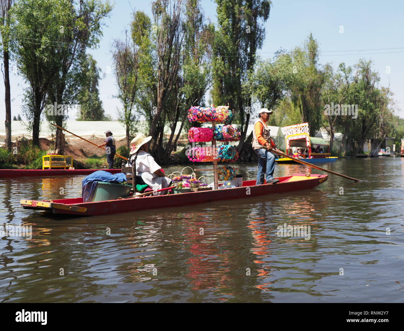 Three colorful boats with tourists and gondoliers at Floating Gardens ...