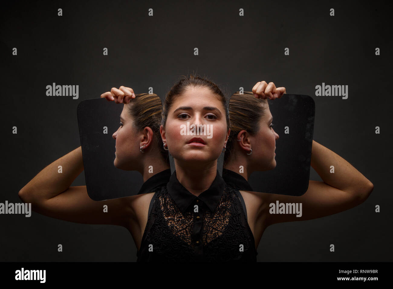 Beautiful confident Woman in lace shirt holding mirrors on sides of ...