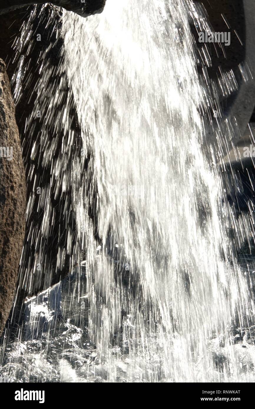 A close up view a water flowing in a blur from a waterfall from a long ...