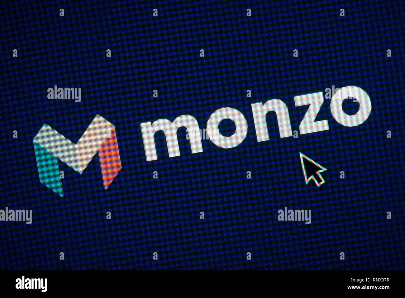 The logo of Monzo is seen on a computer screen along with a mouse ...