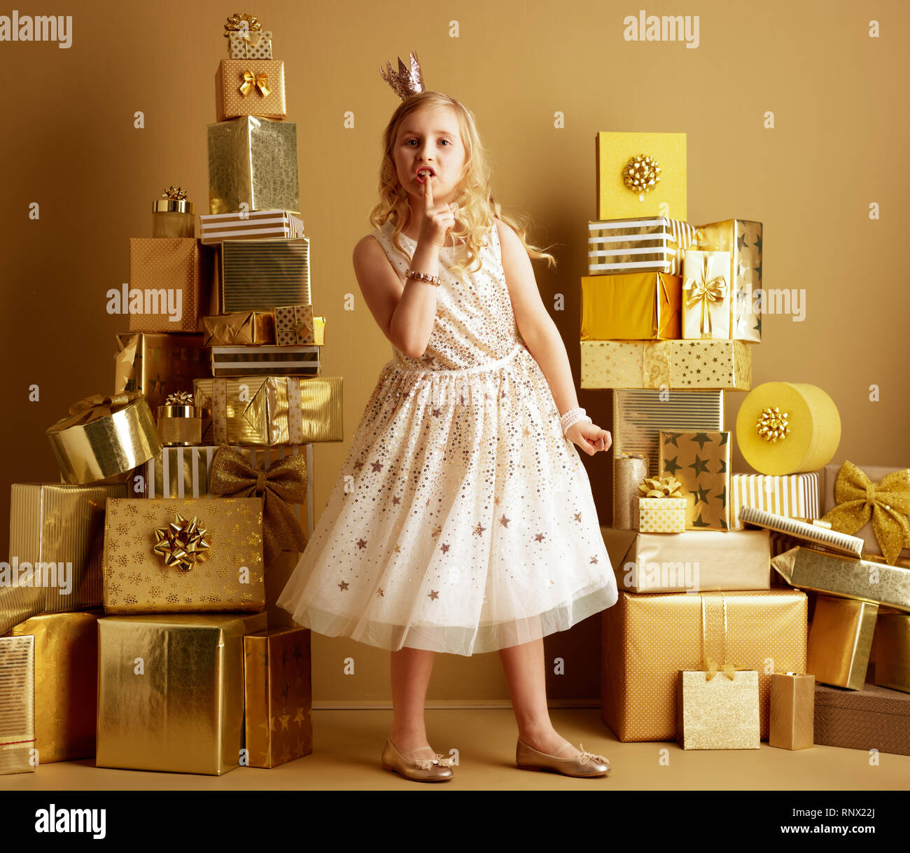 Full length portrait of modern little princess in beige fit and flare ...