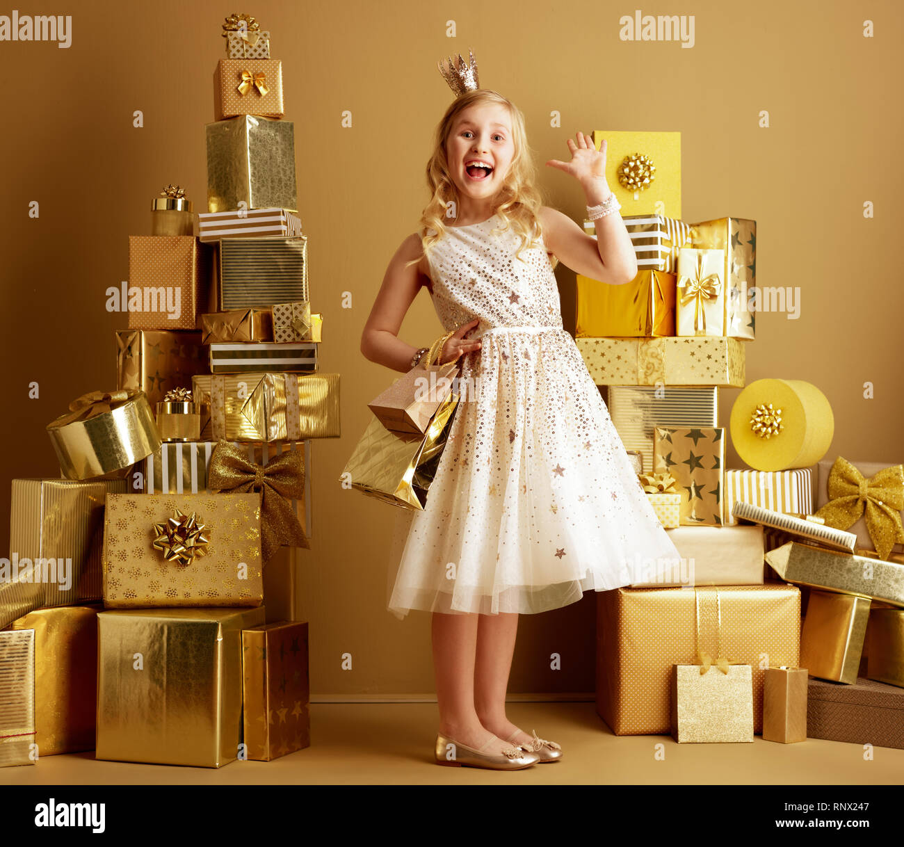 Full length portrait of happy elegant little princess in beige fit and ...