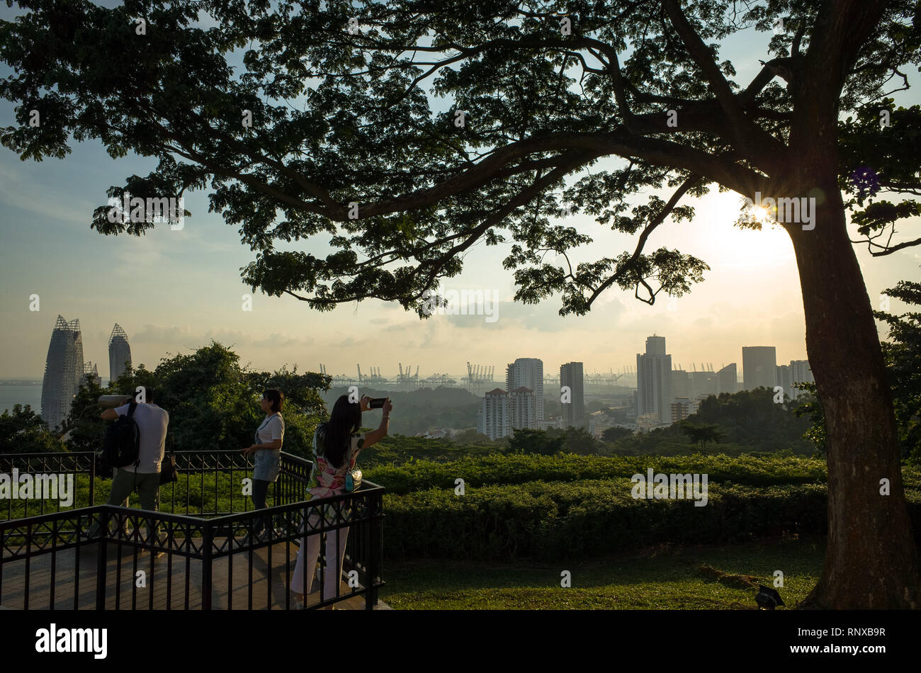 Tourists taking pictures of sunset over skyscrapers on Mount Faber Park ...