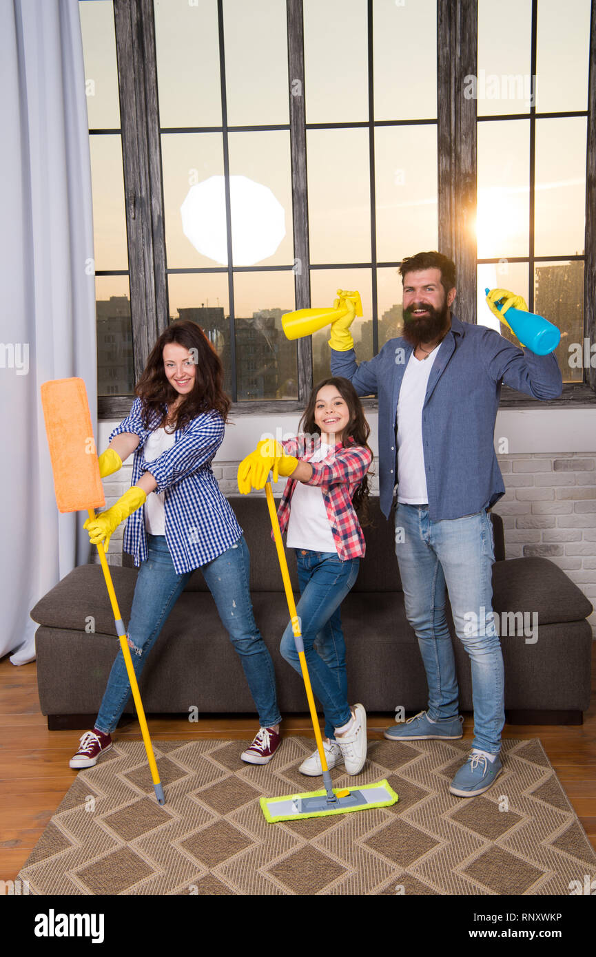 Family mom dad and daughter with cleaning supplies at living room. We ...